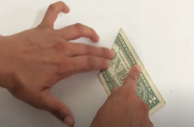 ¿Cómo doblar un dólar en triángulo para la buena suerte?