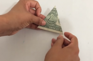 ¿Cómo doblar un dólar en triángulo para la buena suerte?